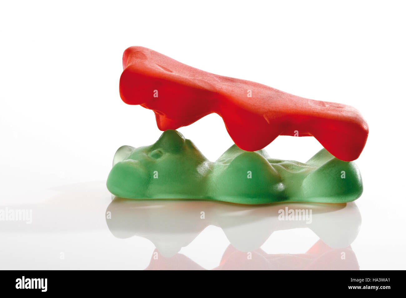 Two multicoloured gummi bears, lying on each other Stock Photo - Alamy