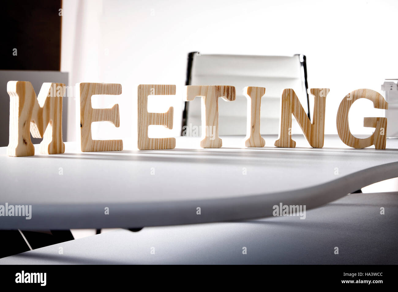 Desk and "Meeting" written in wooden letters Stock Photo - Alamy