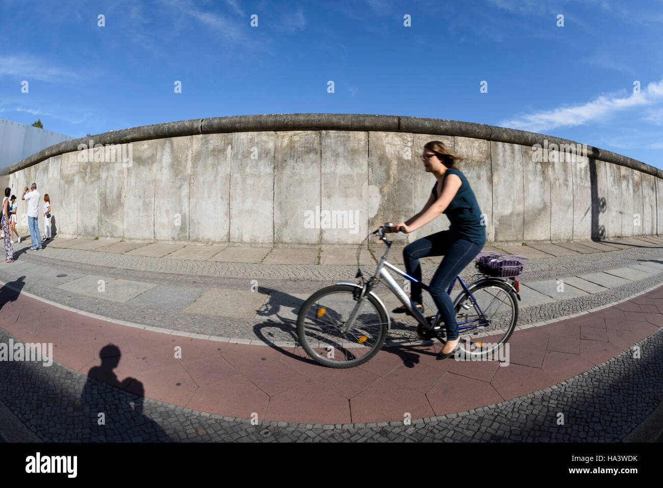 Berlin. Germany. Cyclist riding past a section of the Berlin Wall on ...