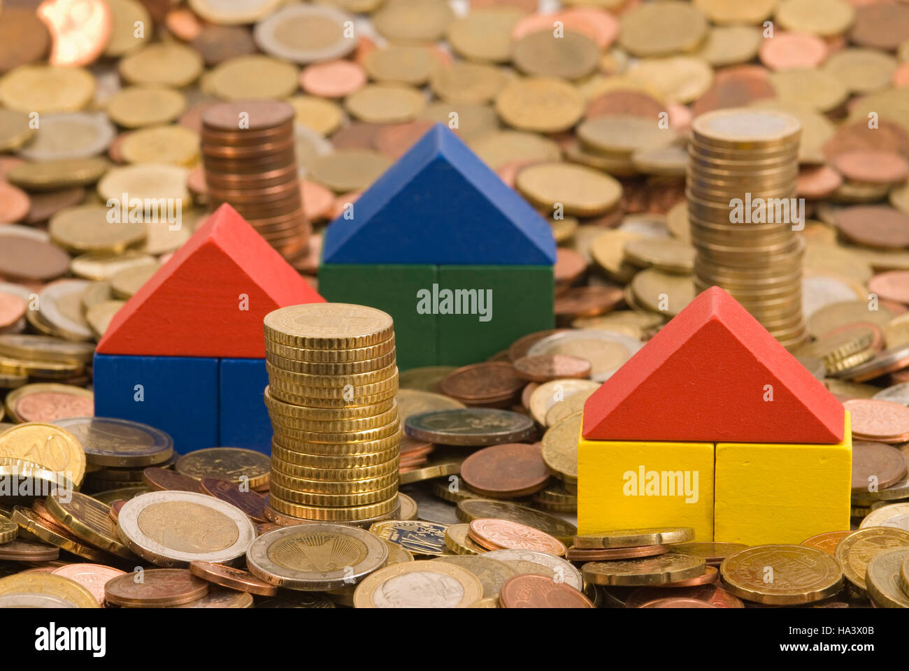 Housees made of toy building bricks on coins, symbolic picture for ...