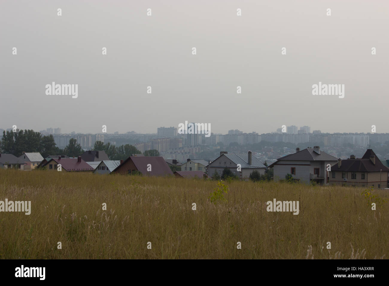 modern city buildings behind old farm houses Stock Photo - Alamy