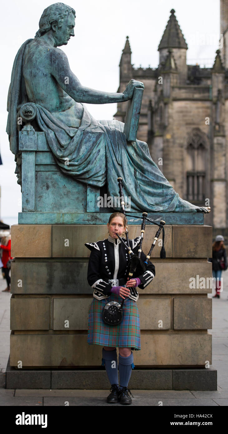 A piper plays the bagpipes at the statue of philosopher David Hume ...