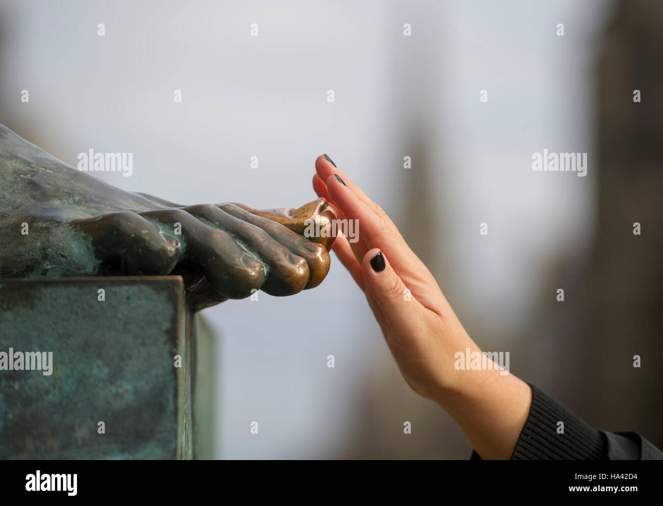 Tourist touches the big toe on the statue of philosopher David Hume ...
