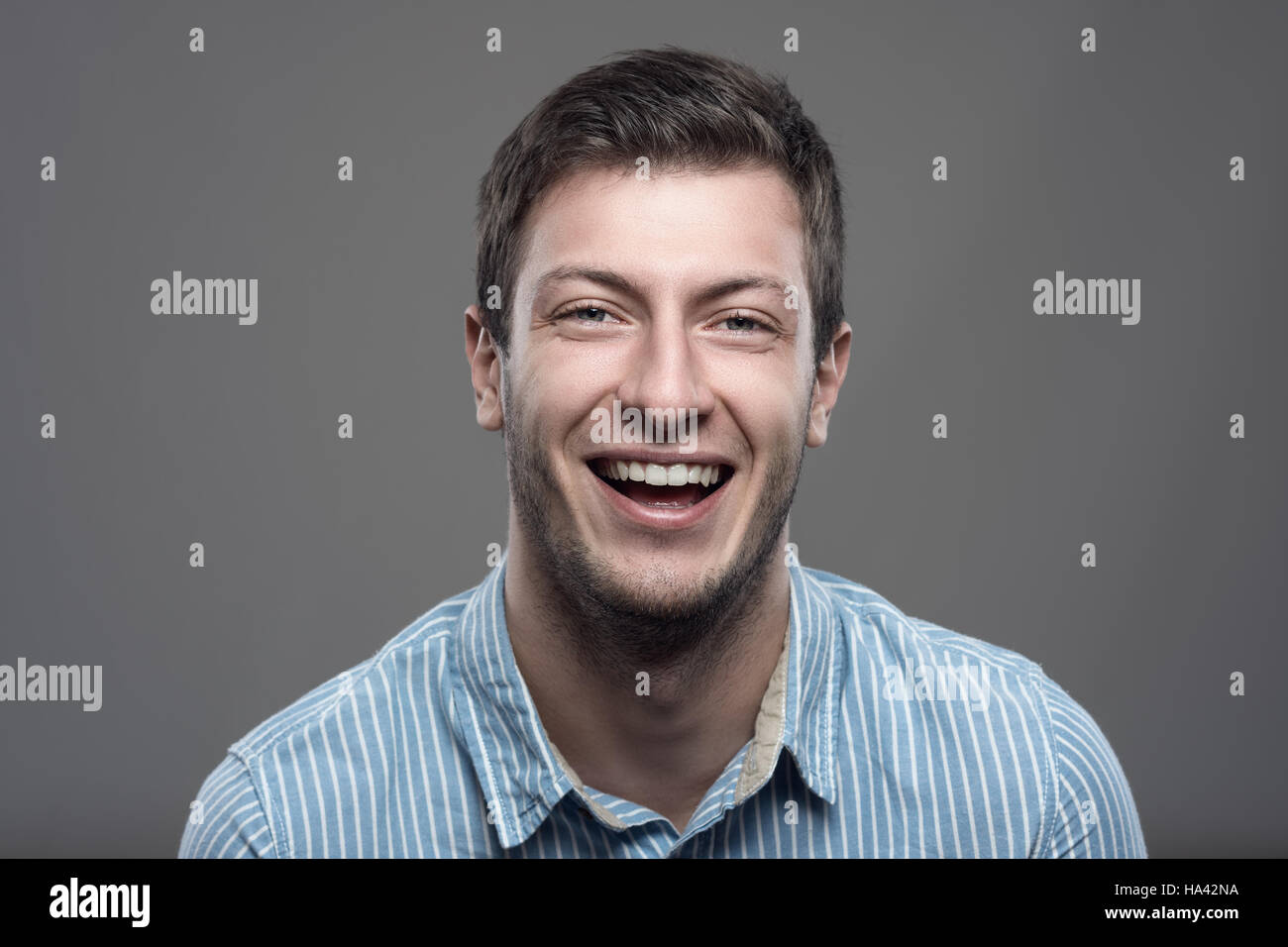 Close up moody horizontal portrait of young successful man laughing and ...