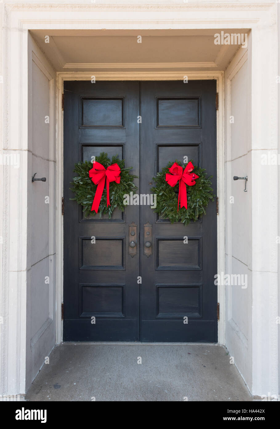 Two Christmas Wreaths on Building Doors with large red ribbons Stock ...