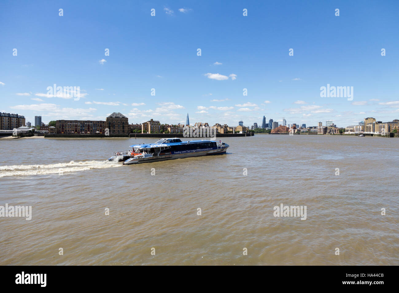 A Thames Clippers ferry travelling along the River Thames, with London ...