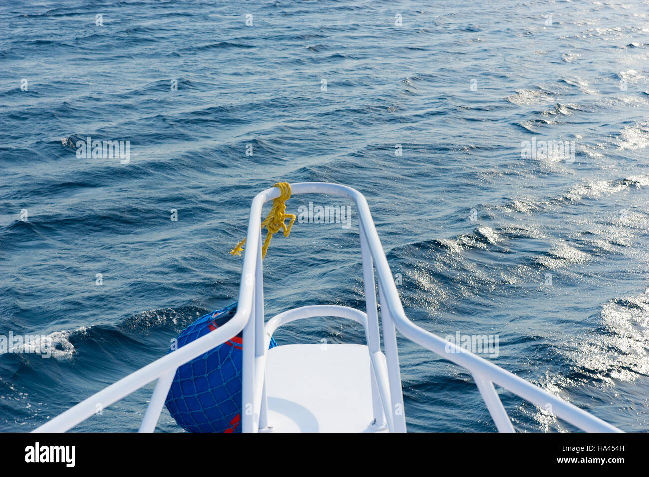 The nose of the yacht during sailing on a blue sea, water waves caused ...