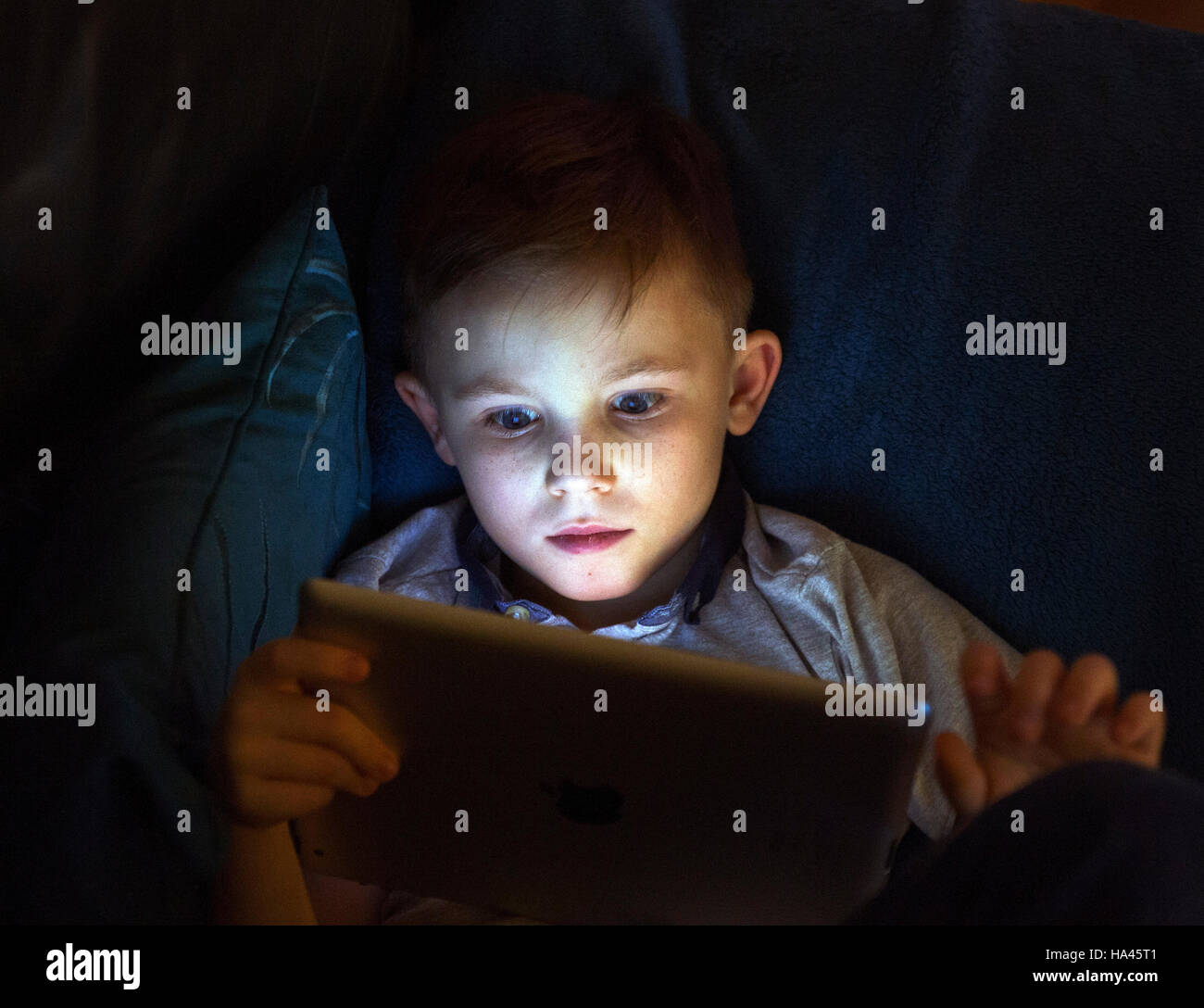 Young boy sitting using Apple ipad to access the internet using ...
