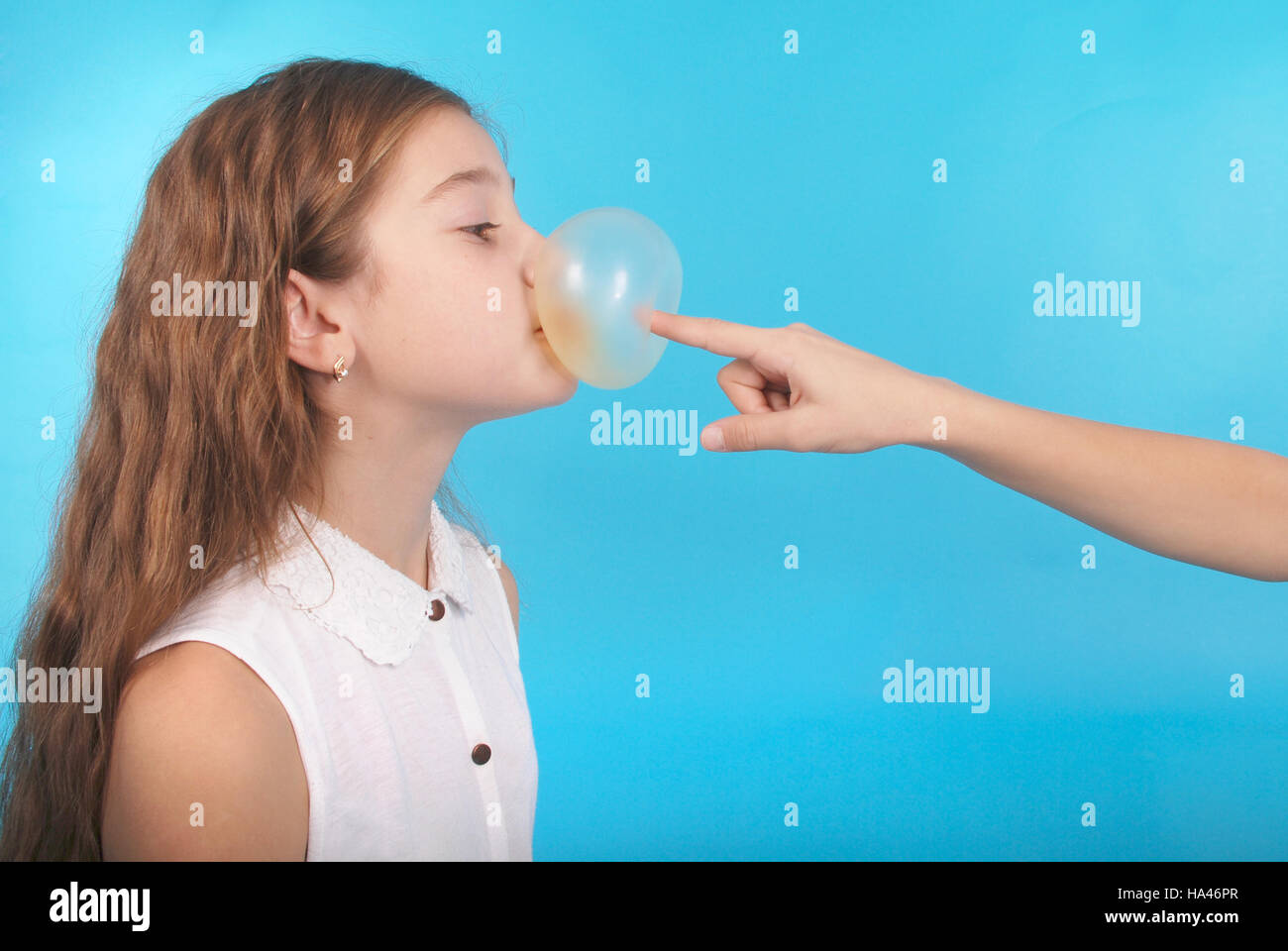 Two young girls playing with chewing gum isolated on blue Stock Photo ...
