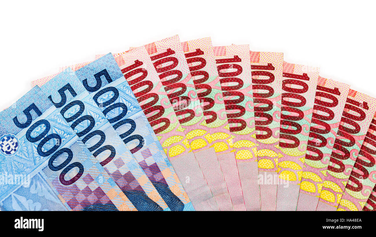Piles of Indonesian Rupiah (IDR) banknotes on the white background ...