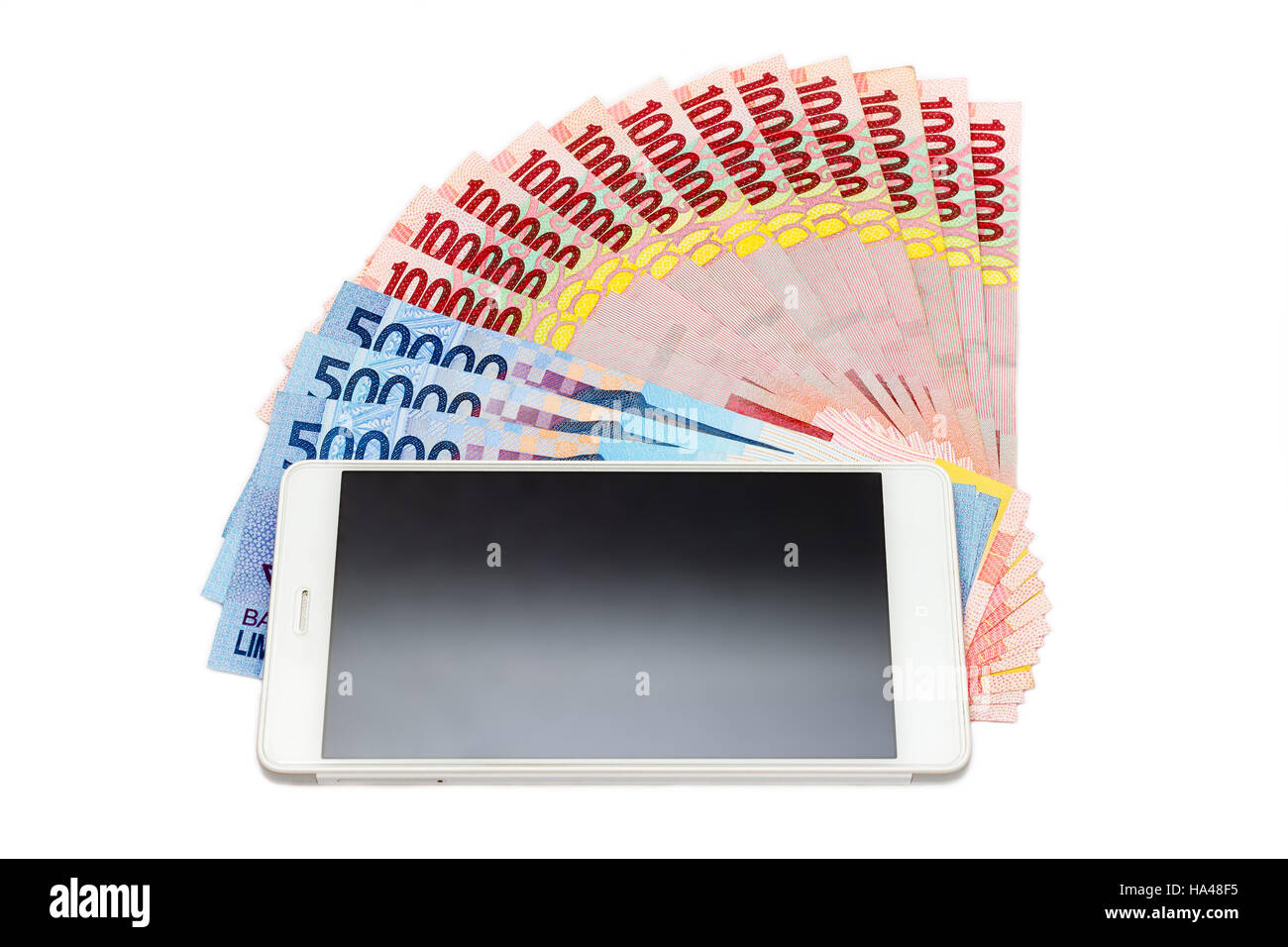 Smartphone above the piles of Indonesian Rupiah (IDR) banknotes on the ...