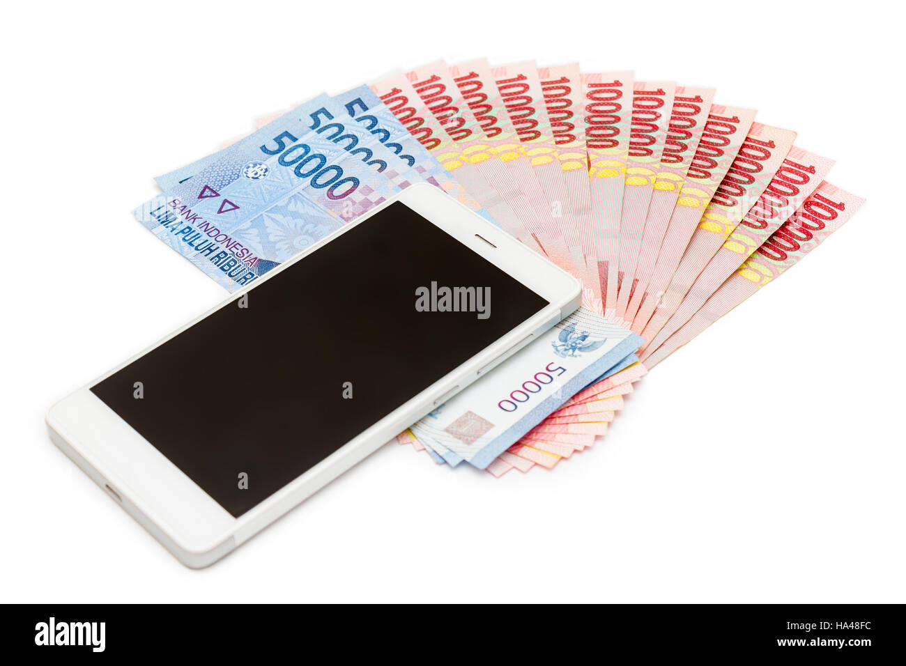 Smartphone above the piles of Indonesian Rupiah (IDR) banknotes on the ...