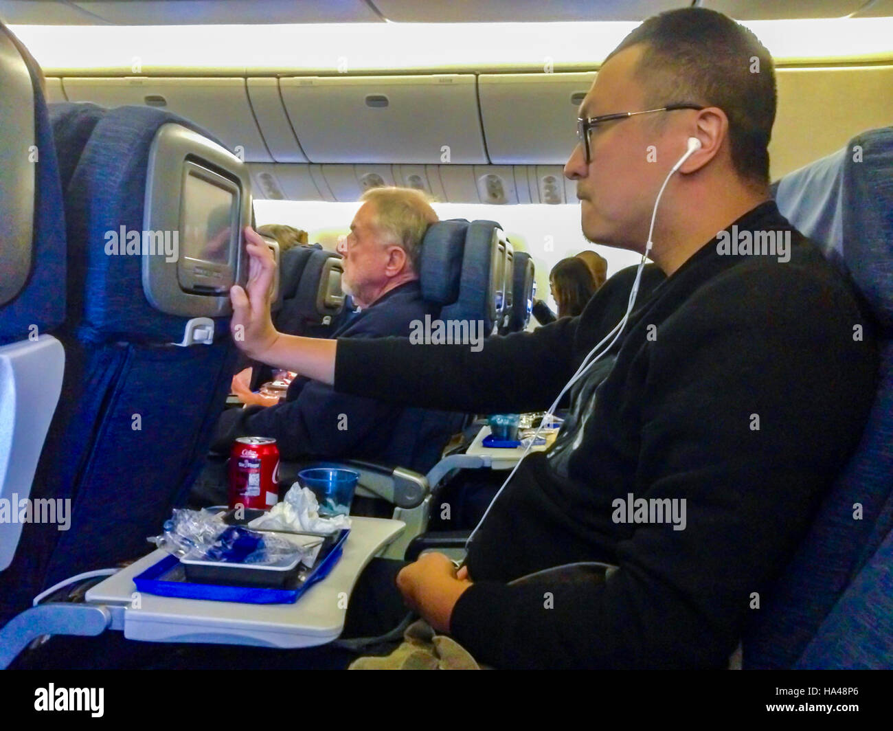 Men Sitting onboard Airplane, Watching Videos, Eating Meals, people ...