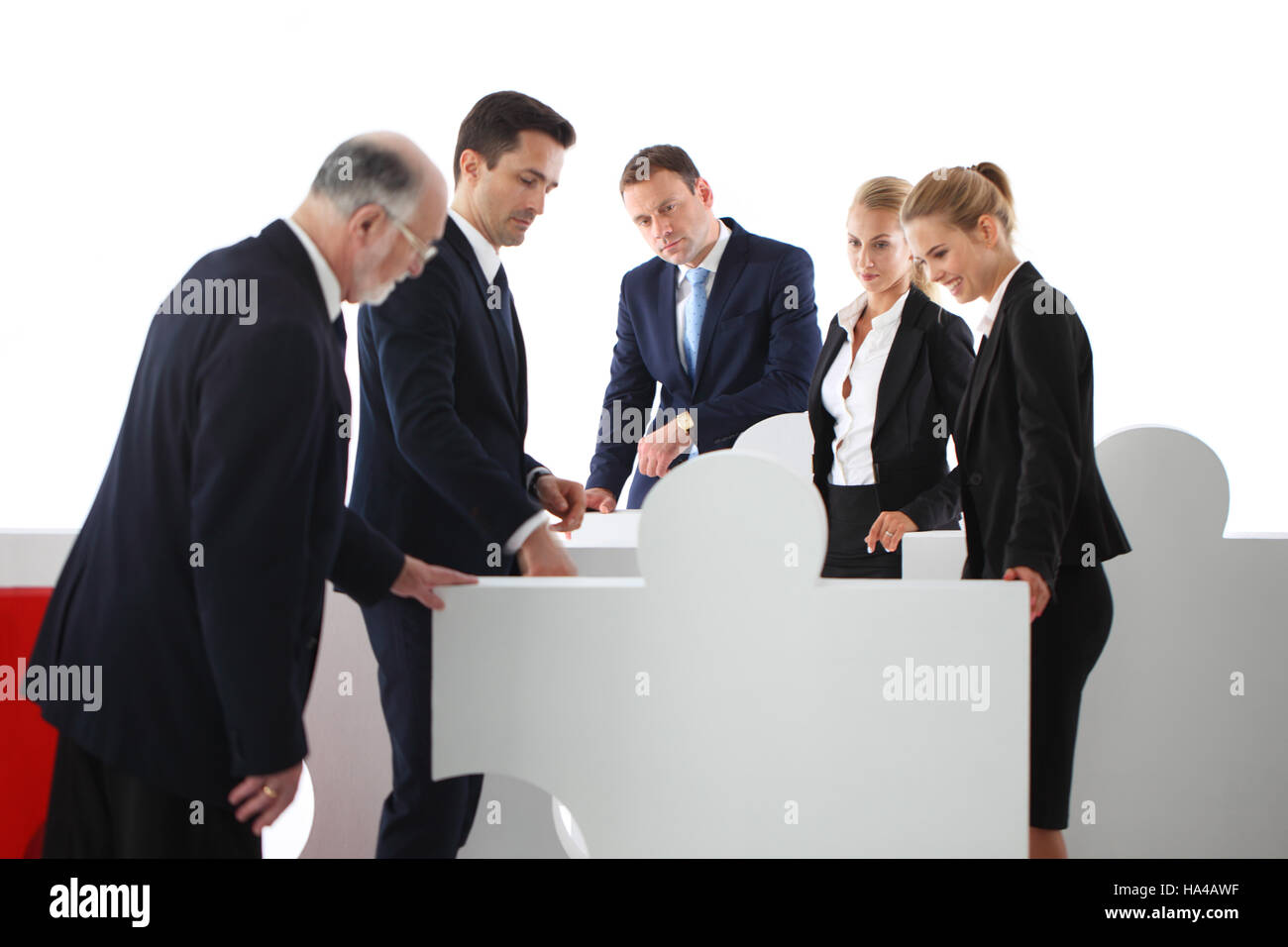 Group of business people assembling pieces of a puzzle isolated on ...