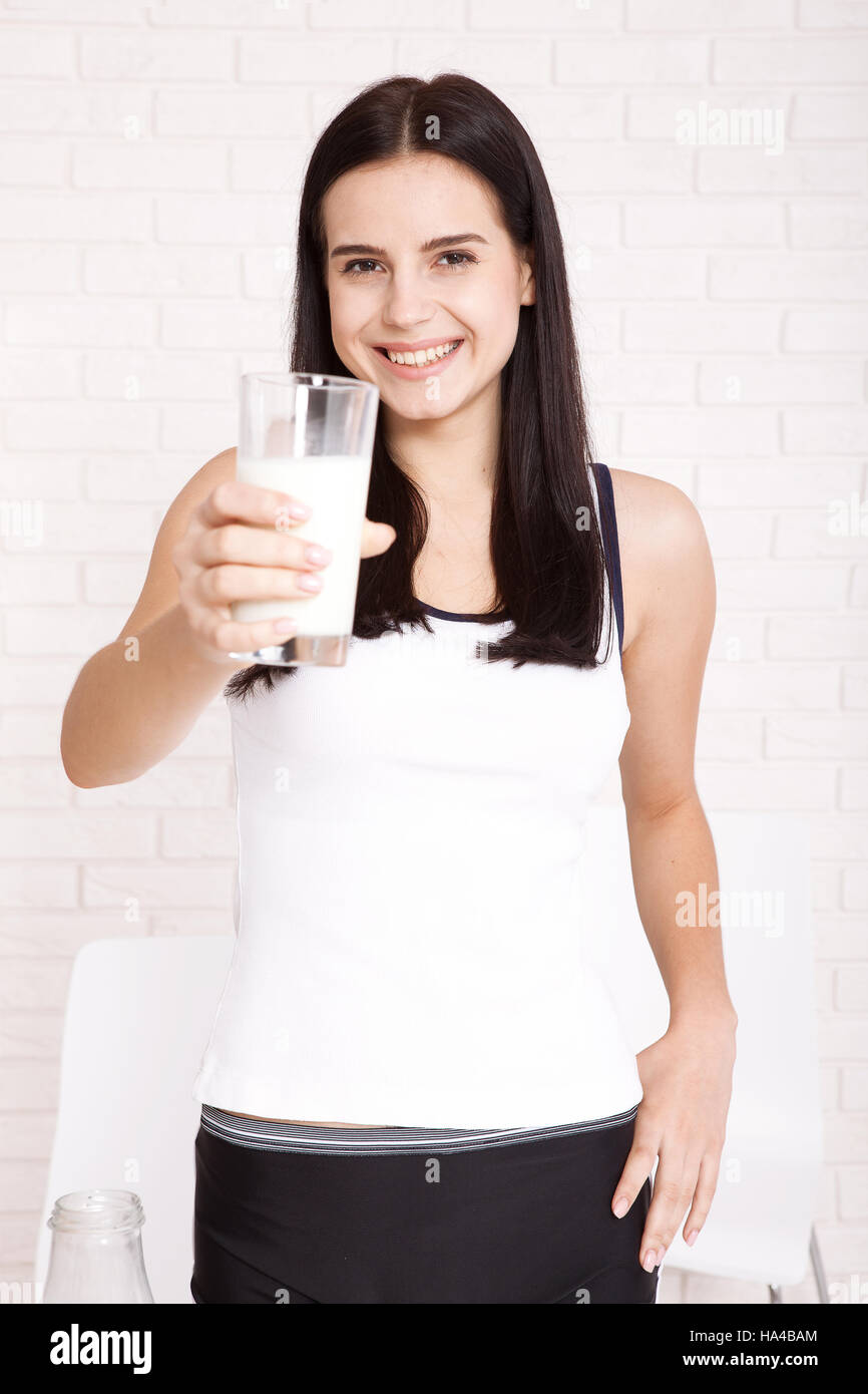 Happy young woman drinking milk Stock Photo - Alamy