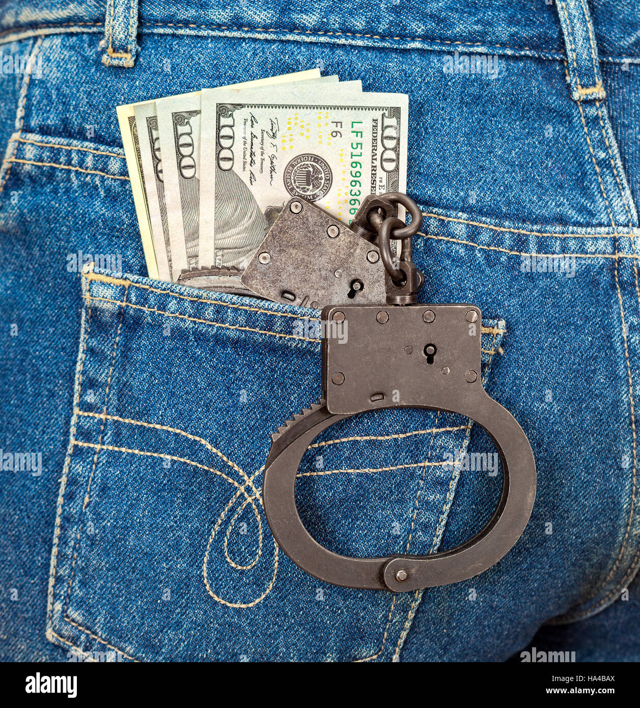 Black metal handcuffs and american currency in back jeans pocket Stock ...