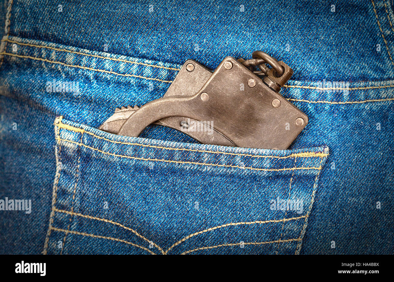 Black metal handcuffs in back jeans pocket Stock Photo - Alamy