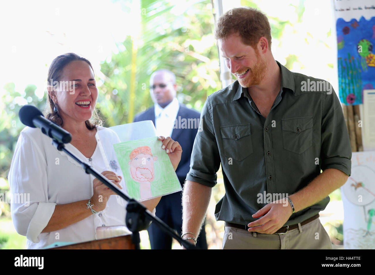 Prince Harry looks at a portrait of himself which was drawn by a child ...