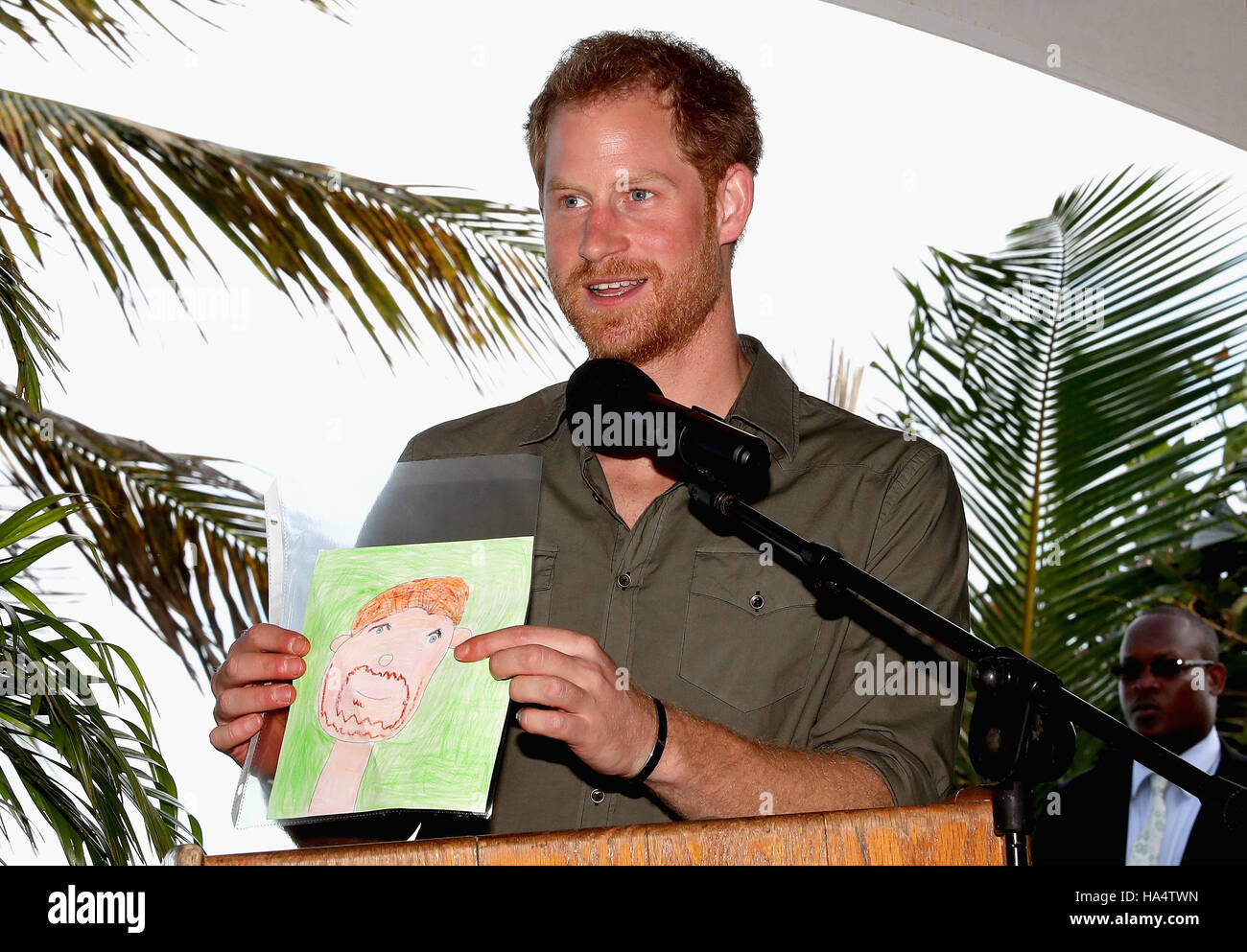 Prince Harry holds a portrait of himself which was drawn by a child ...