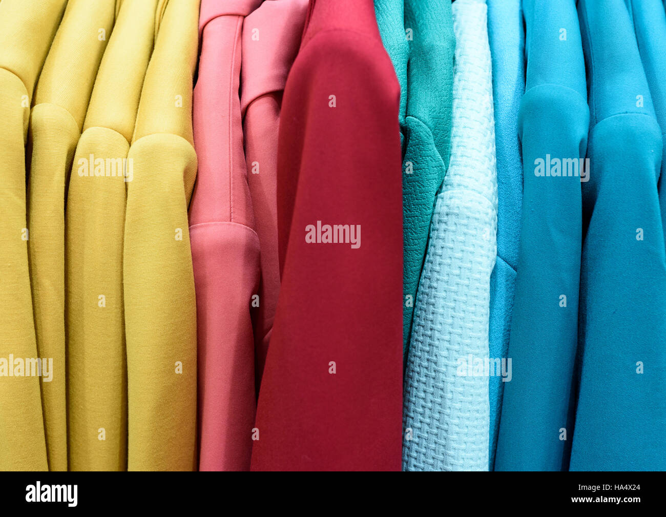 Vertical rows of brightly colored womens coats and clothes inside a ...