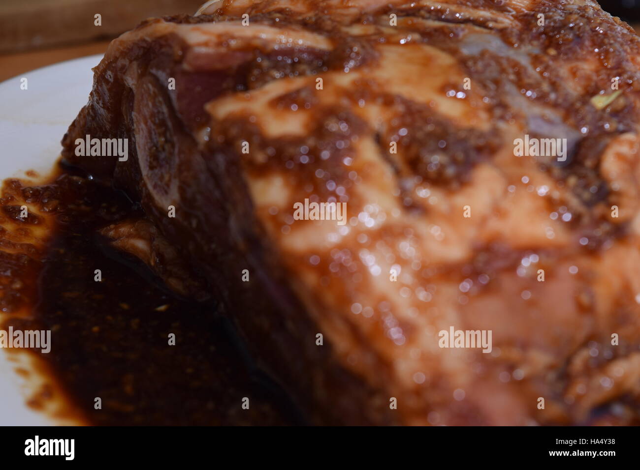 Close perspective of brown marinade on a white plate Stock Photo - Alamy