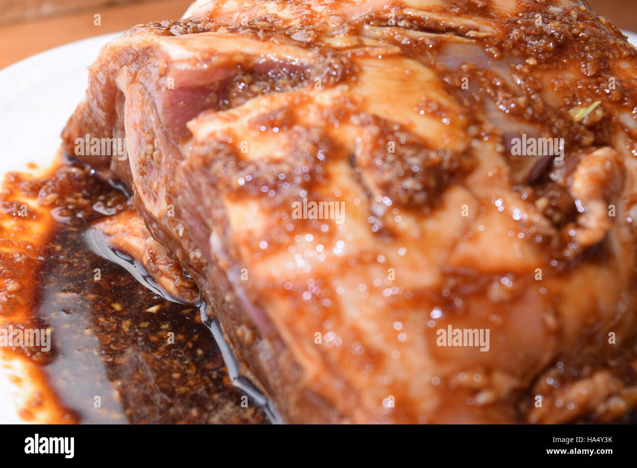 Brown marinade on a plate to soak a juicy lamb shoulder Stock Photo - Alamy