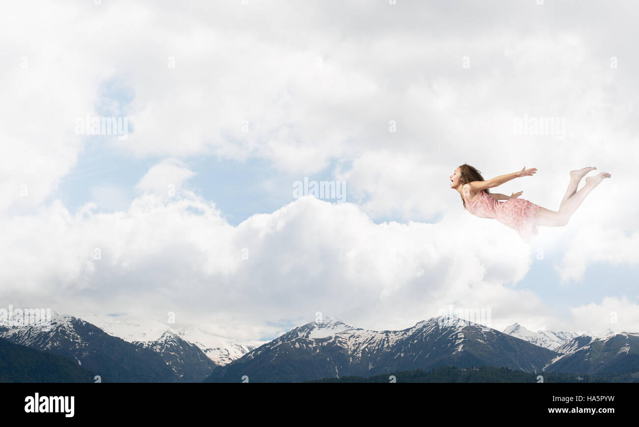 Young woman flying high in blue sky Stock Photo - Alamy