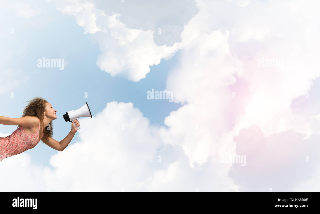 Young woman shouting in megaphone with blue sky background Stock Photo ...