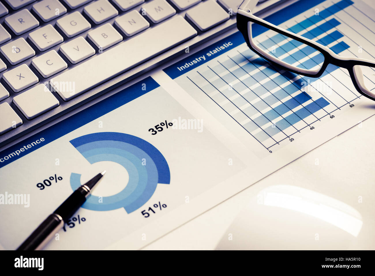 Business workplace with keyboard mouse and papers with graphs and ...