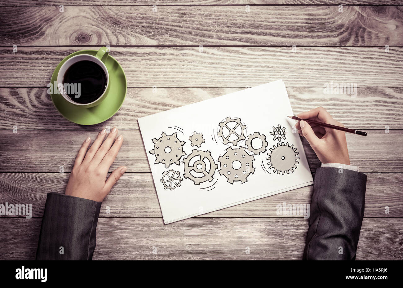 To view of businesswoman hands drawing on paper sheet gears mechanism ...
