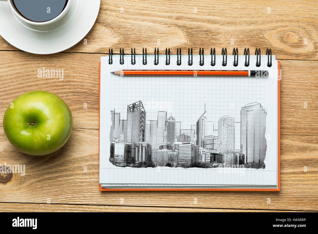 Wooden table with coffee cup and architectural sketches on notepad ...