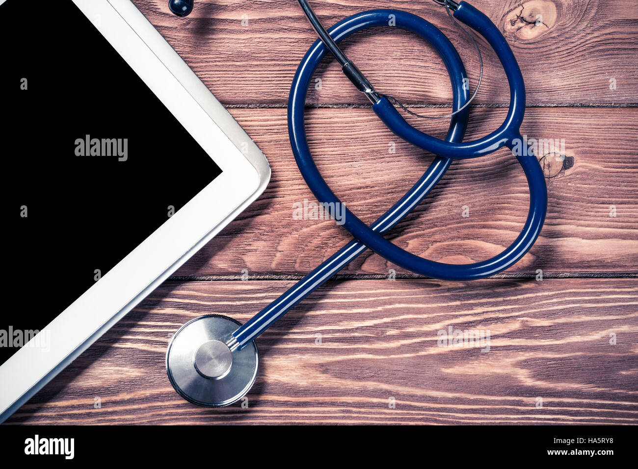 Doctors wooden table with white tablet and stethoscope Stock Photo - Alamy