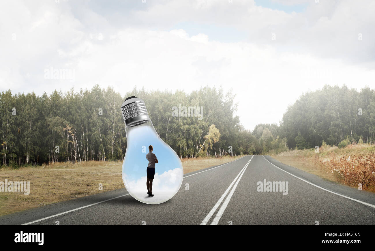 Young businesswoman trapped inside of light bulb on asphalt road Stock ...