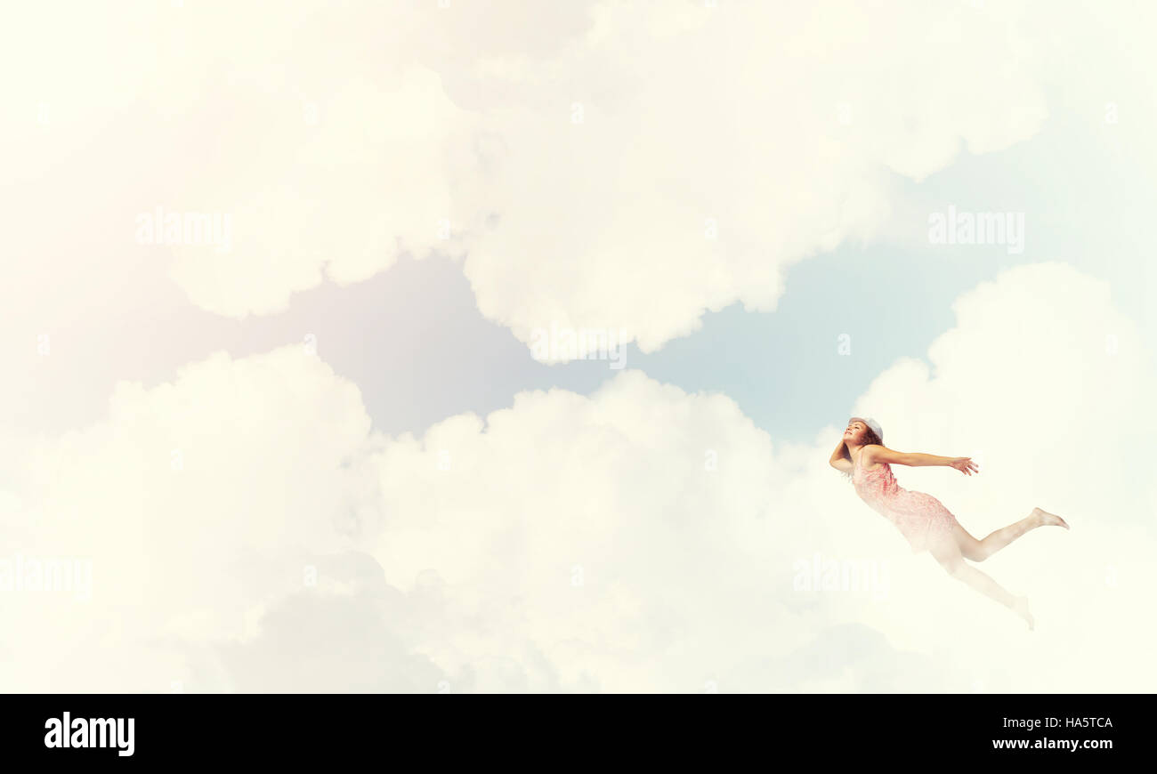 Young woman flying high in blue sky Stock Photo - Alamy