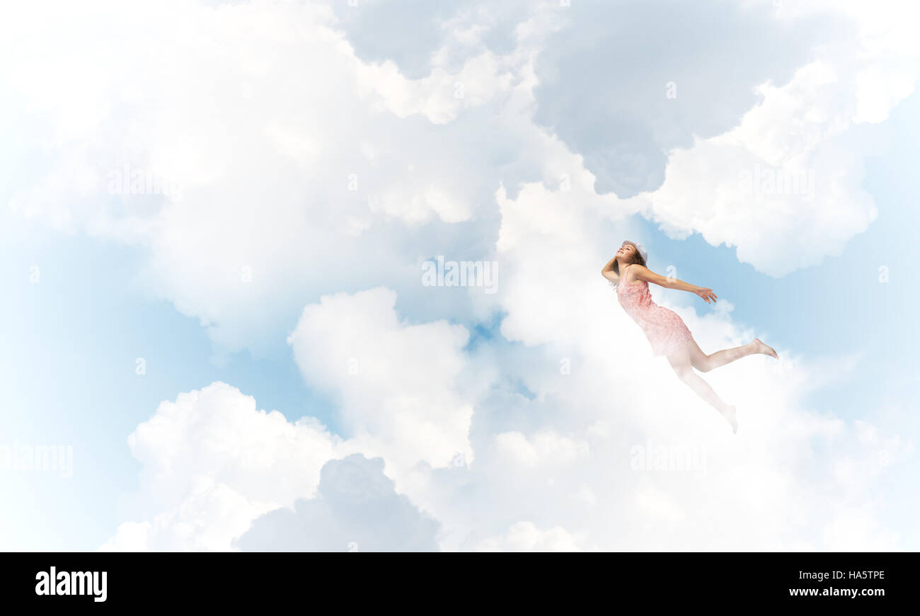 Young woman flying high in blue sky Stock Photo - Alamy