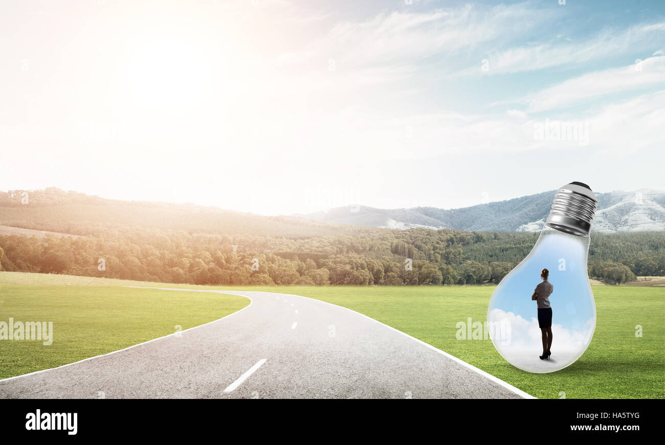 Young businesswoman trapped inside of light bulb on asphalt road Stock ...
