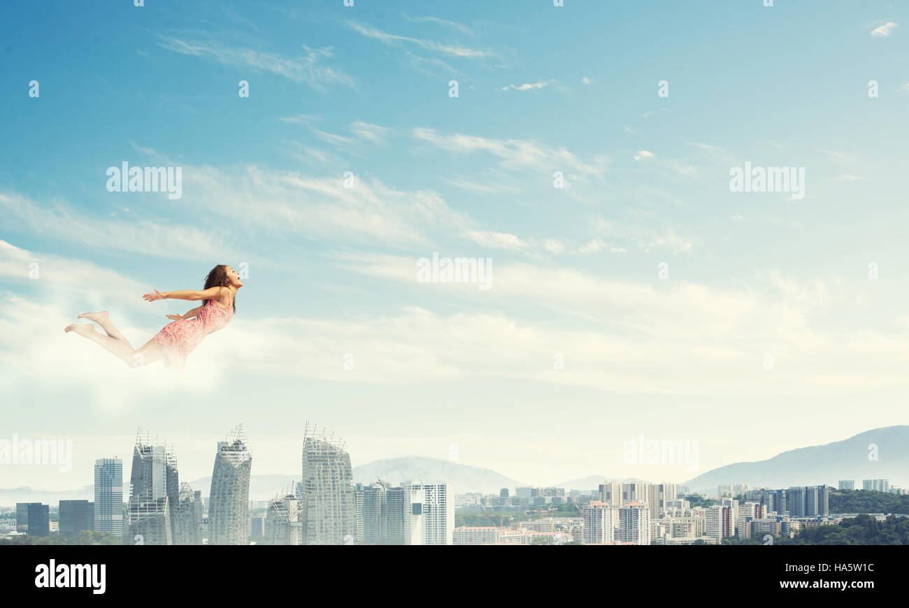 Young woman flying high in blue sky Stock Photo - Alamy