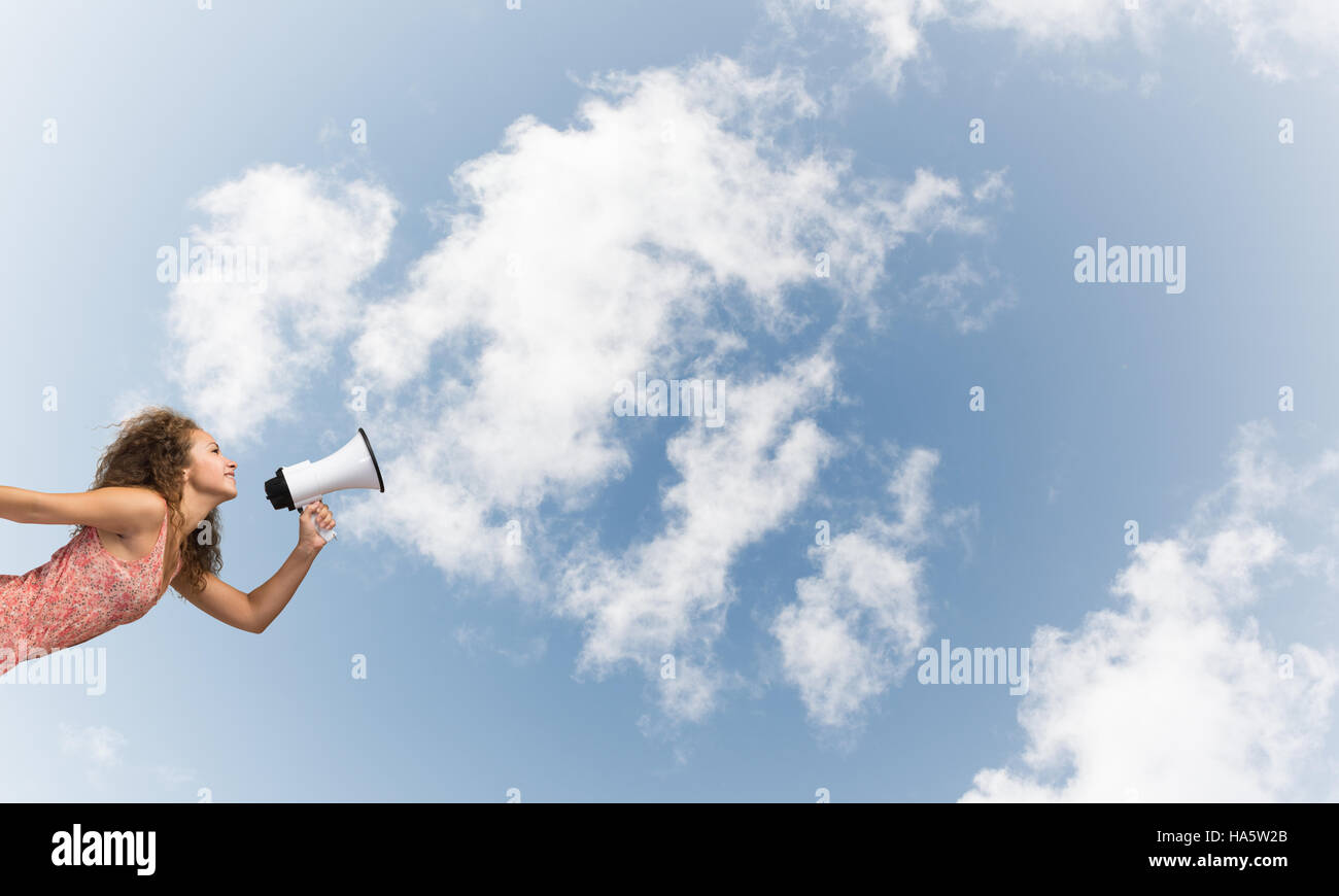 Young woman shouting in megaphone with blue sky background Stock Photo ...