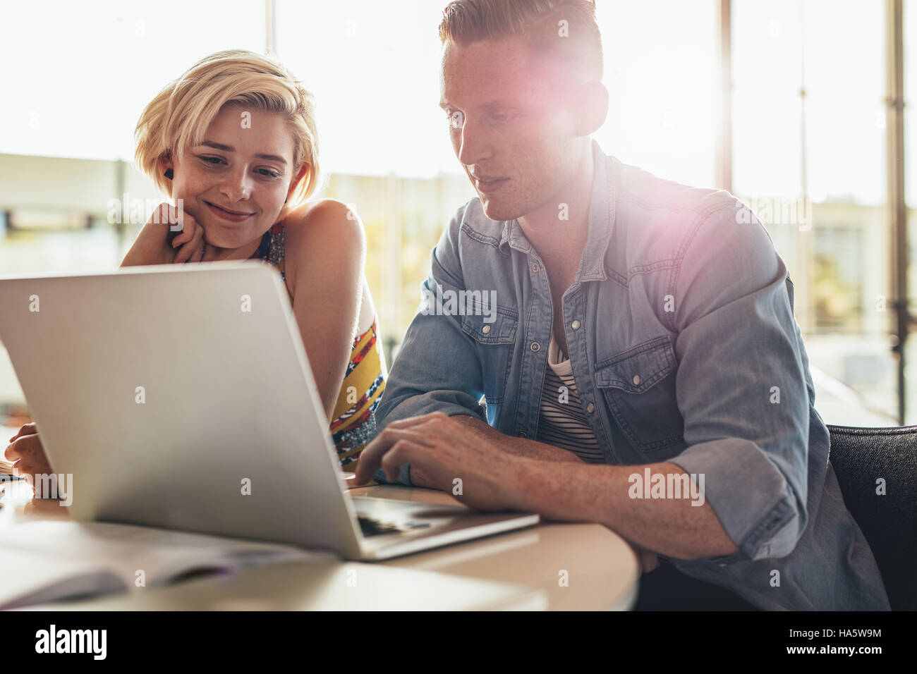 Two young students using laptop in class. university students working ...