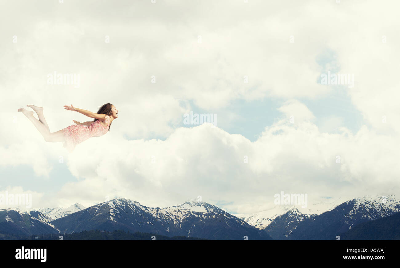 Young woman flying high in blue sky Stock Photo - Alamy
