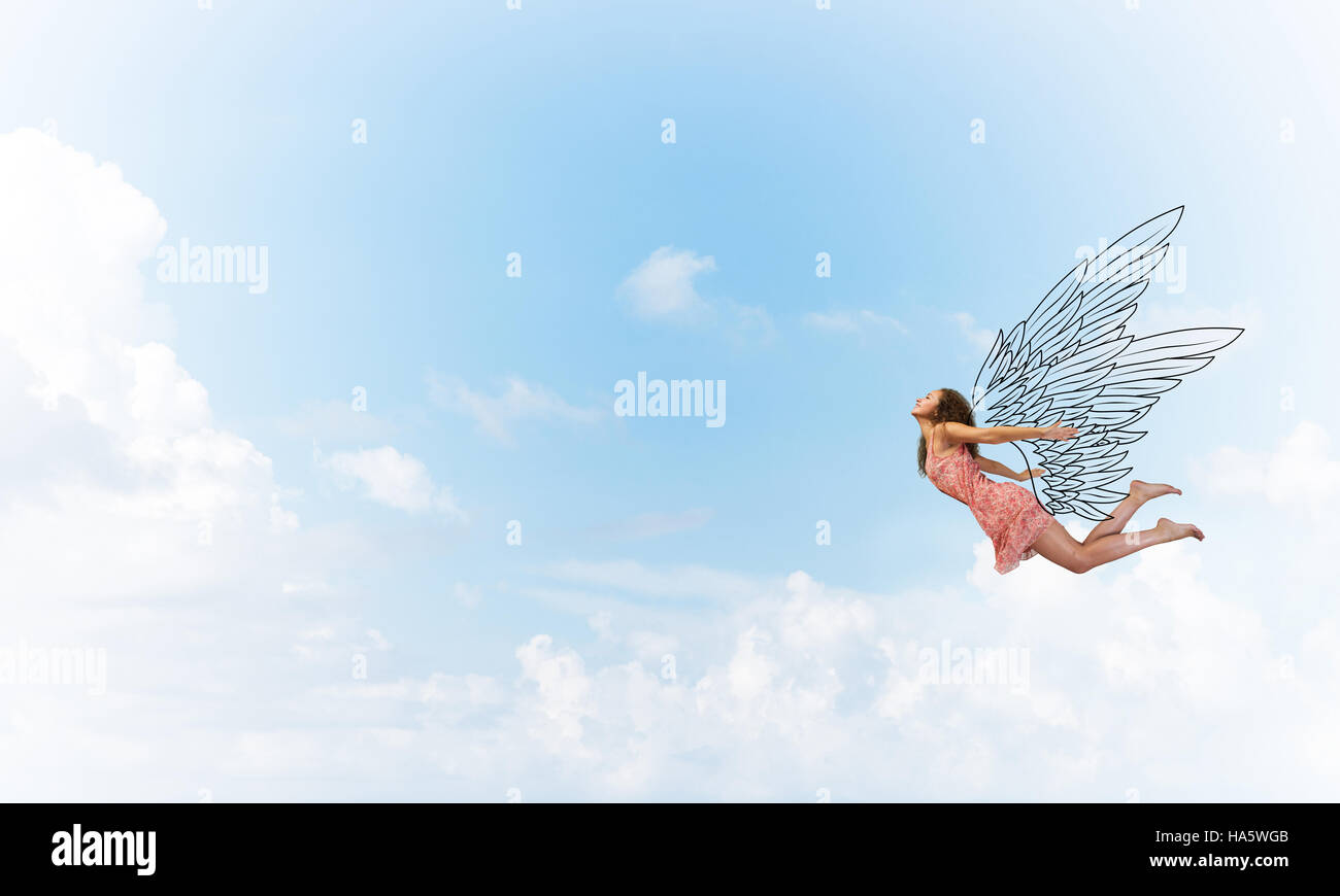 Young woman flying high in blue sky Stock Photo - Alamy