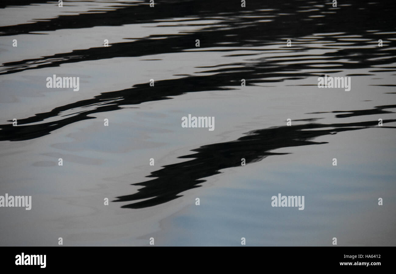 Ripples on water with unusual reflections of black, grey and cyan Stock ...