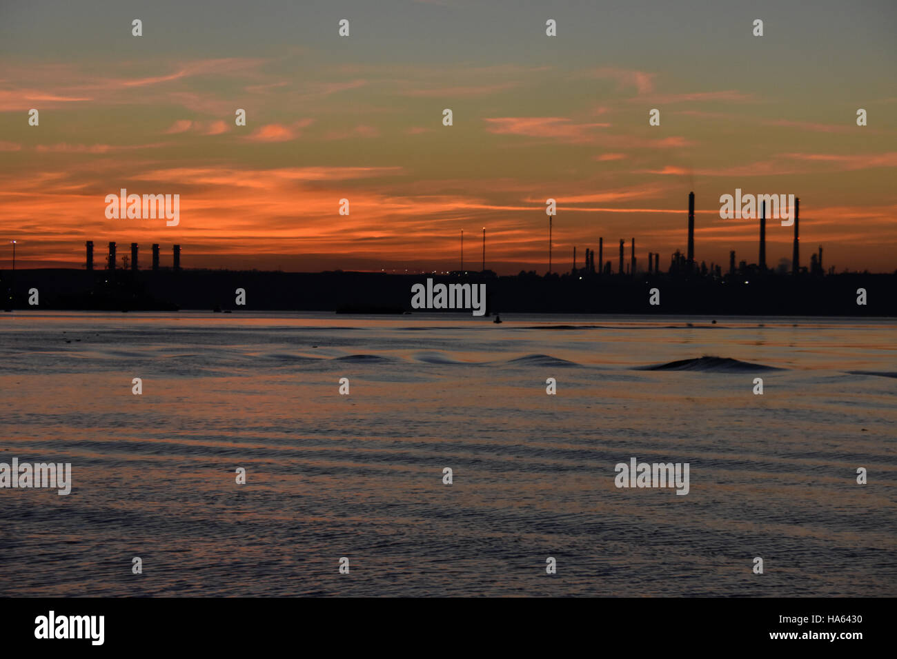 Pembroke power stations and refinery silhouetted in a sunset. Reflected ...