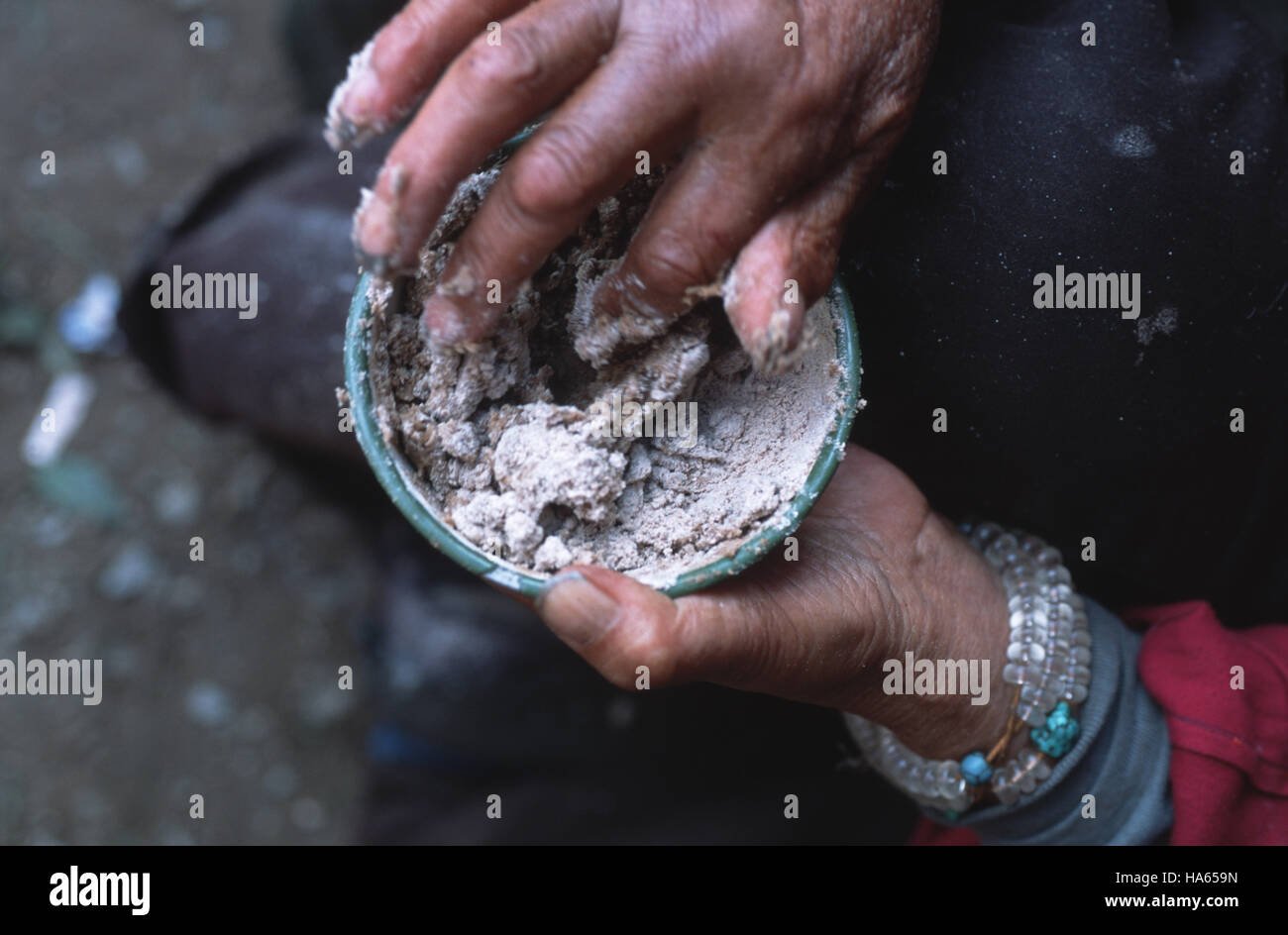 Caption: Axu, Sichuan, China - Aug 2003. An old lady makes tsampa, the ...