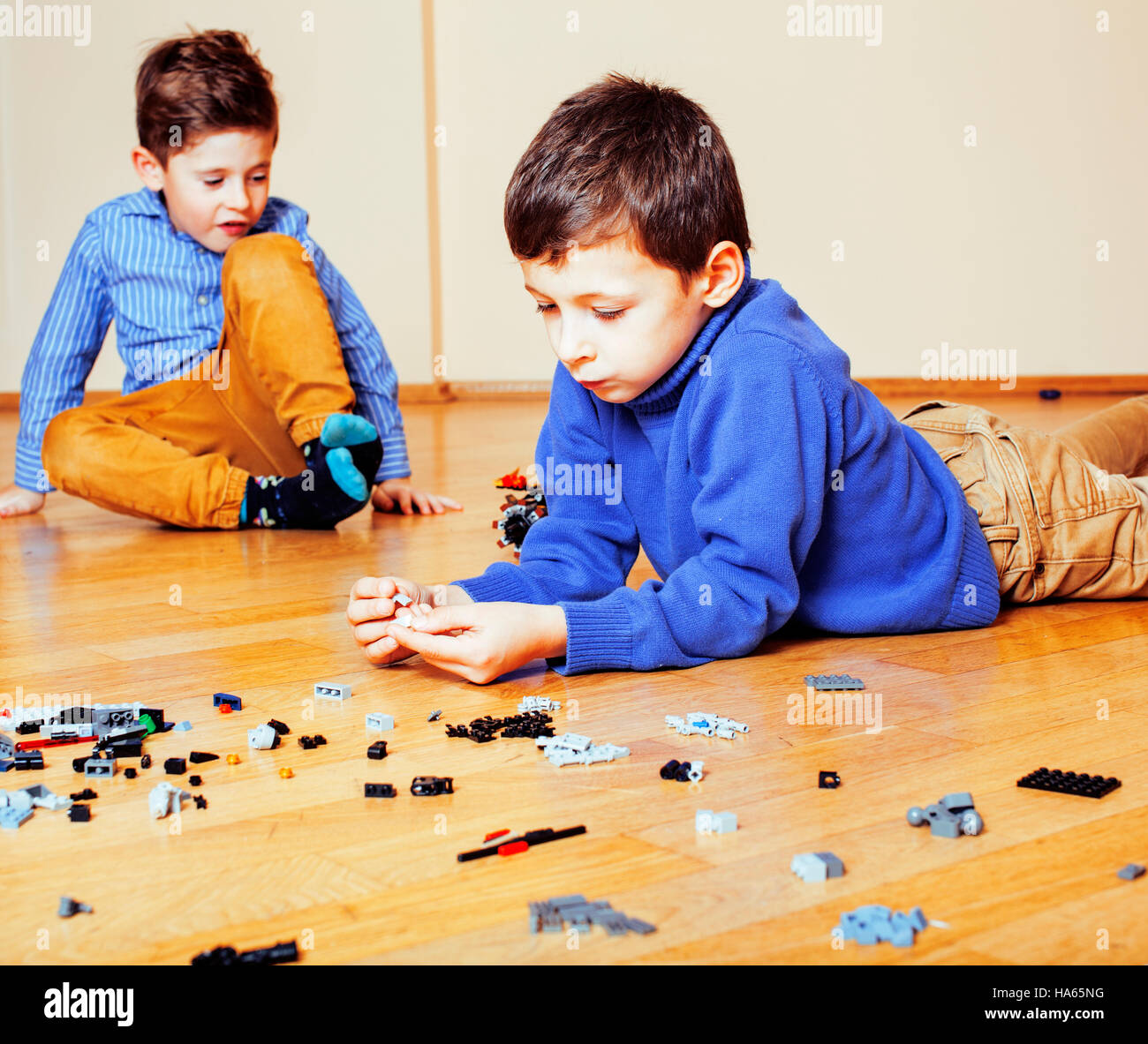 funny cute children playing lego at home, boys and girl smiling, first ...