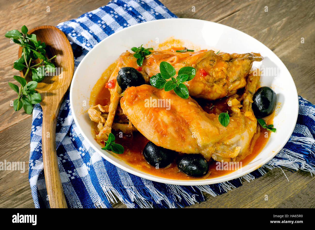 Stewed rabbit legs with black olives and herbs leaves Stock Photo - Alamy
