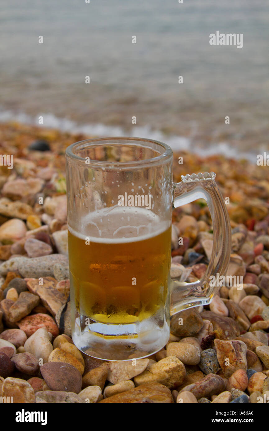 Glass of beer on the pebble beach Stock Photo - Alamy