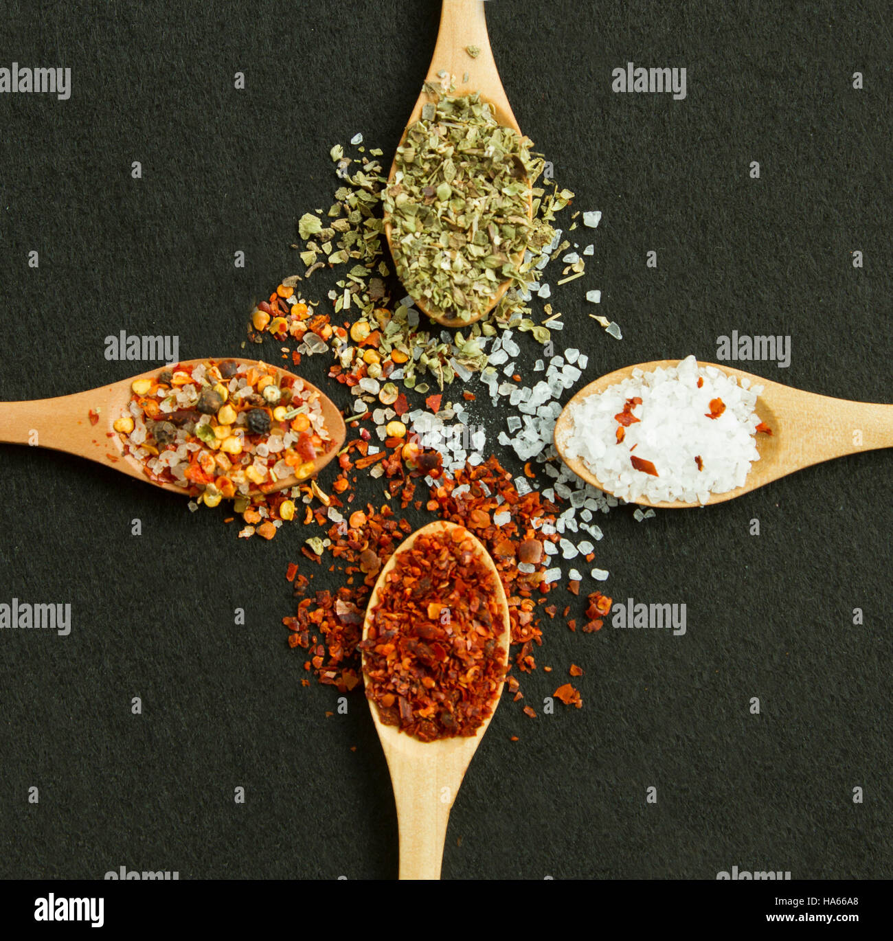 Four spoons with different spices and salt on black background Stock ...