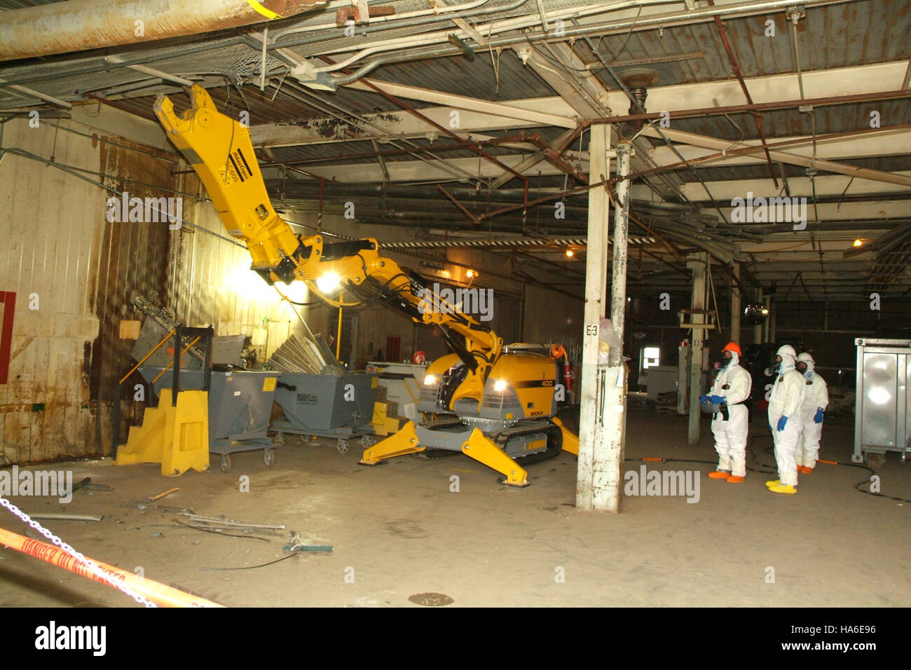The image shows workers using robotics to assist with the cleanup of ...