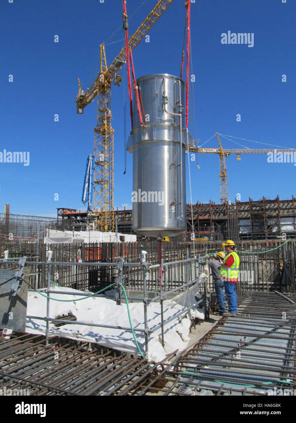 A crane lifts a canister decontamination system vessel into the High ...